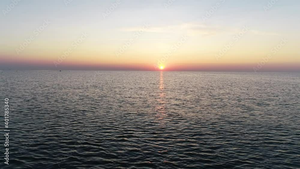 Sunrise along the sea, the camera proceeds in the direction of the sun ...