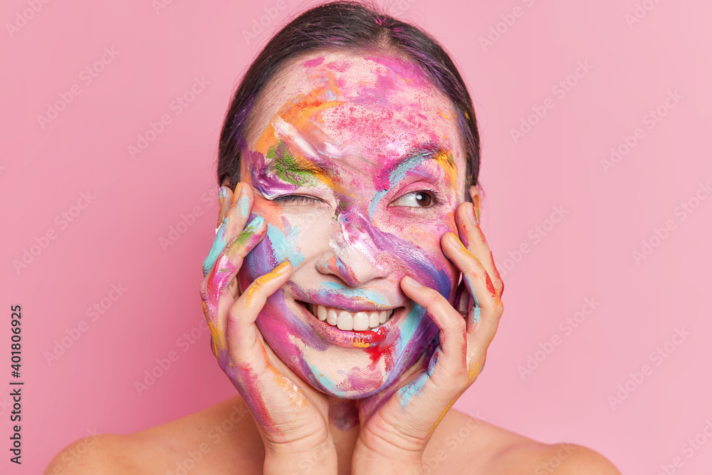 Positive young woman in colorful face paint has abstract makeup ...