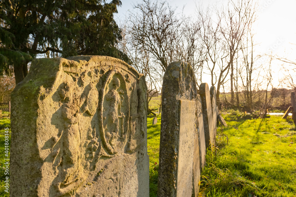 Shallow focus of very old and heavily weathered grave stones seen in a ...