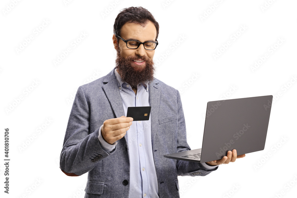 Happy bearded man with a laptop using a credit card for online payment ...