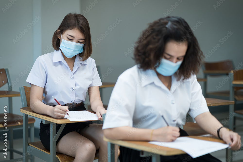 Cheerful college students in the classroom wear protective face masks ...