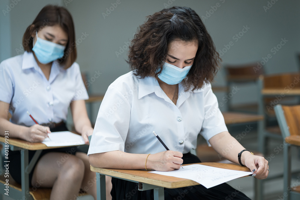Cheerful college students in the classroom wear protective face masks ...
