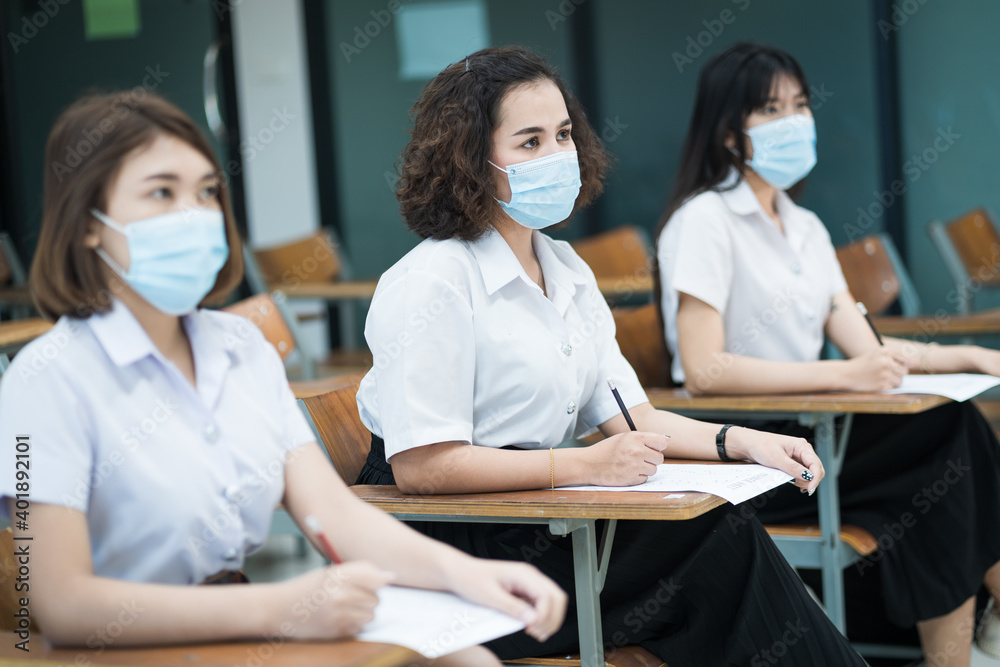 Cheerful college students in classroom wear protective face masks and ...