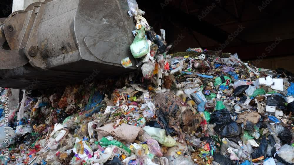 Vidéo Stock A special machine with a bucket heaps a pile of unsorted ...