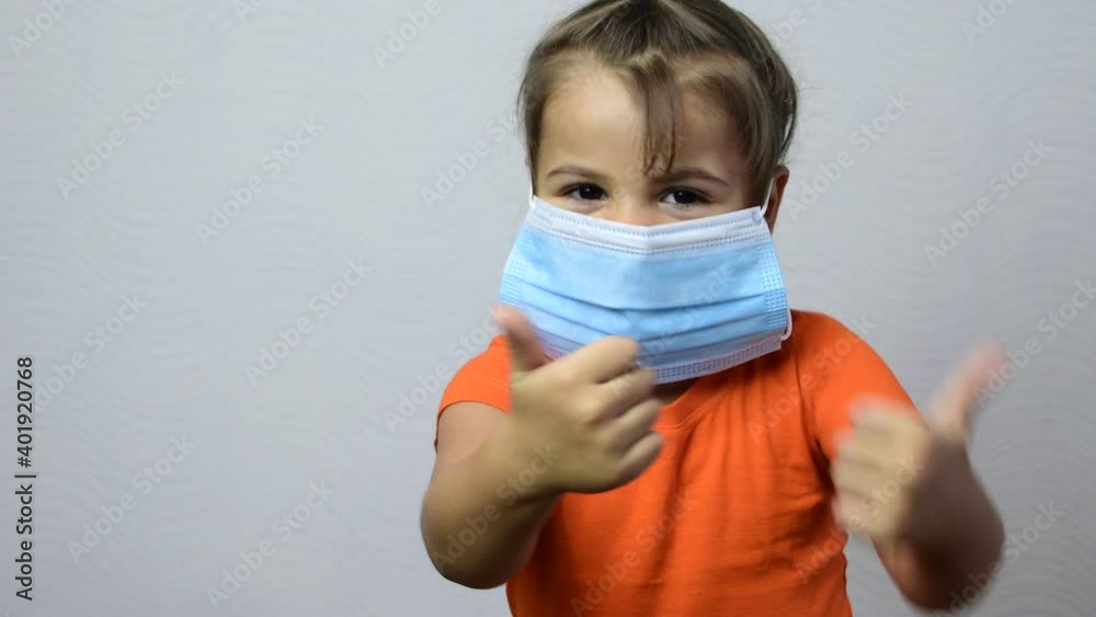 Father wears mediacl mask on a girl with dark brown eyes during the ...