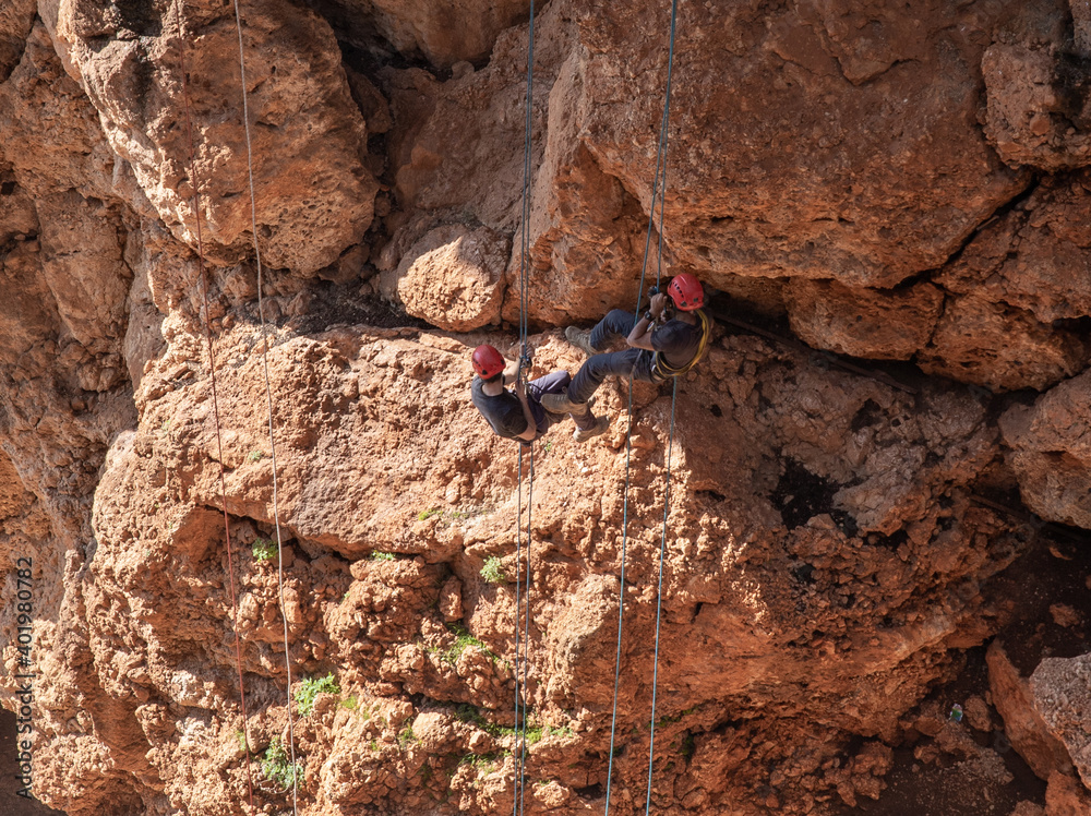 Two athletes make the descent on a rope down - climbing - snapping ...