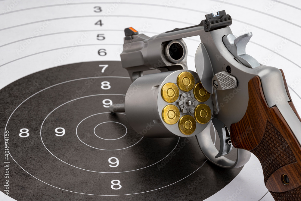 Revolver hand gun and bullets on bull eye target background Stock Photo ...