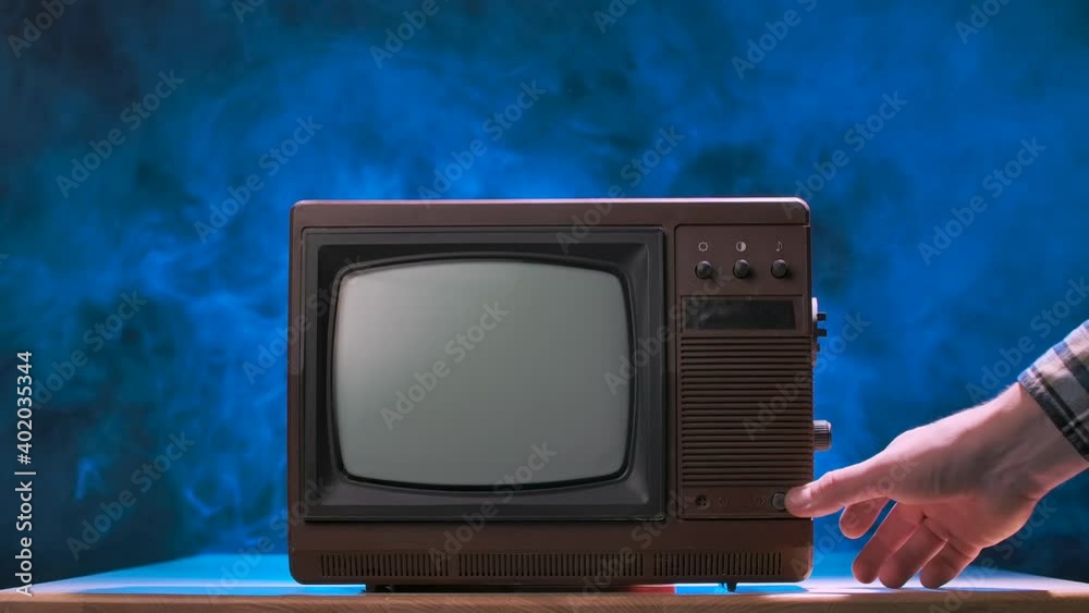 Man tries to turn on the old TV, knocks on it, scattering dust ...