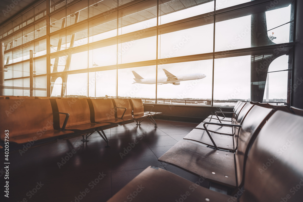 An empty waiting room of a modern airport with rows of wooden seats ...