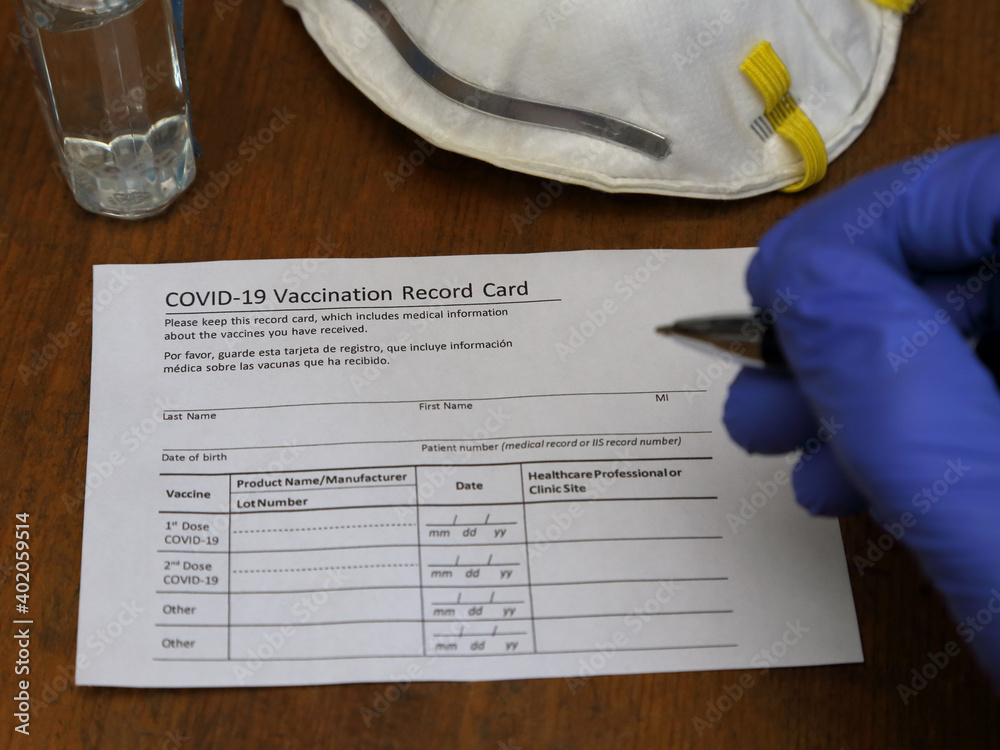 A Coronavirus COVID-19 vaccination record card is shown about to be ...