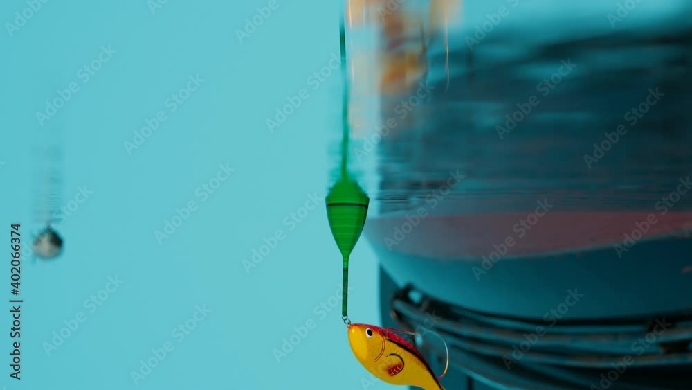 Sinker with a yellow fish bite in the water. Line with lure while ...