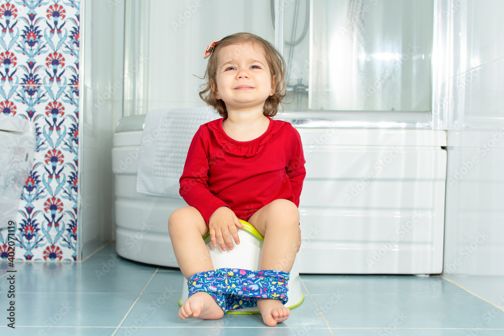 Beautiful little baby sit on potty in bathroom and cry. Cute adorable ...