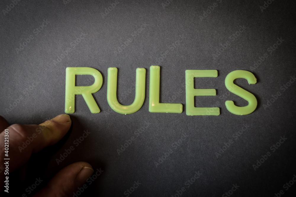 Human finger pointing the word Rules written with plastic letters on ...
