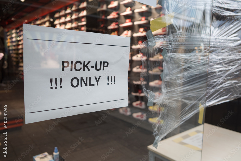 " pick-up only " sign on storefront of sneaker store which closed ...