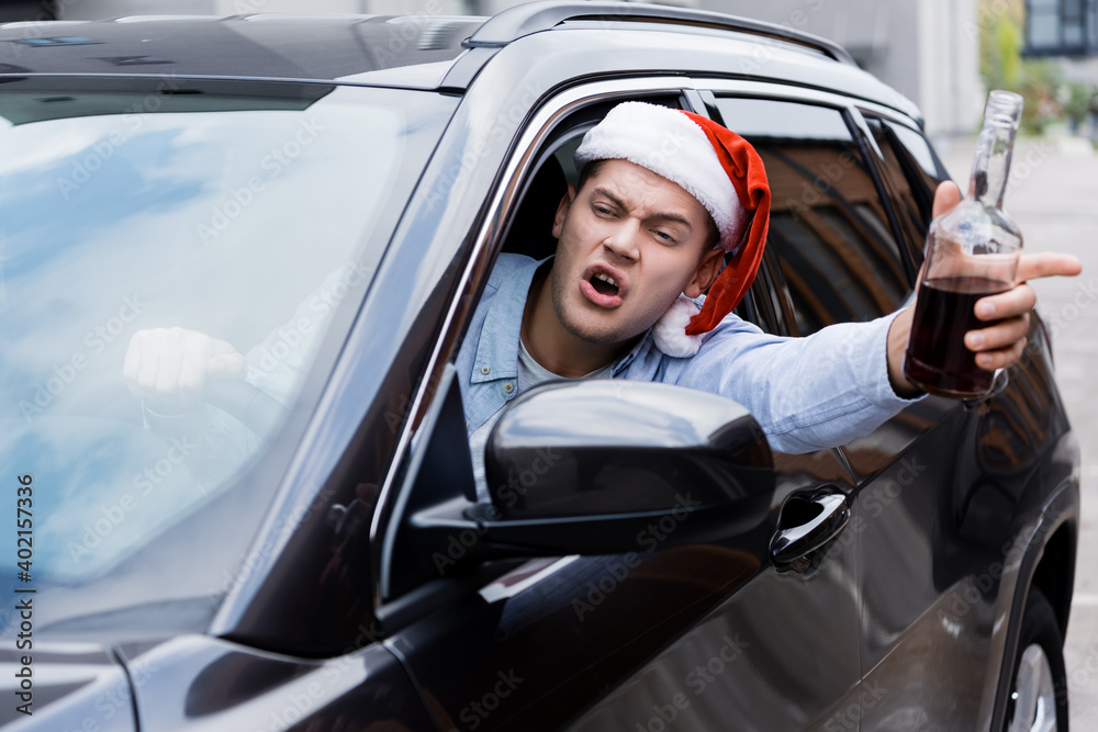 drunk, angry man in santa hat, with bottle of whiskey, looking out ...