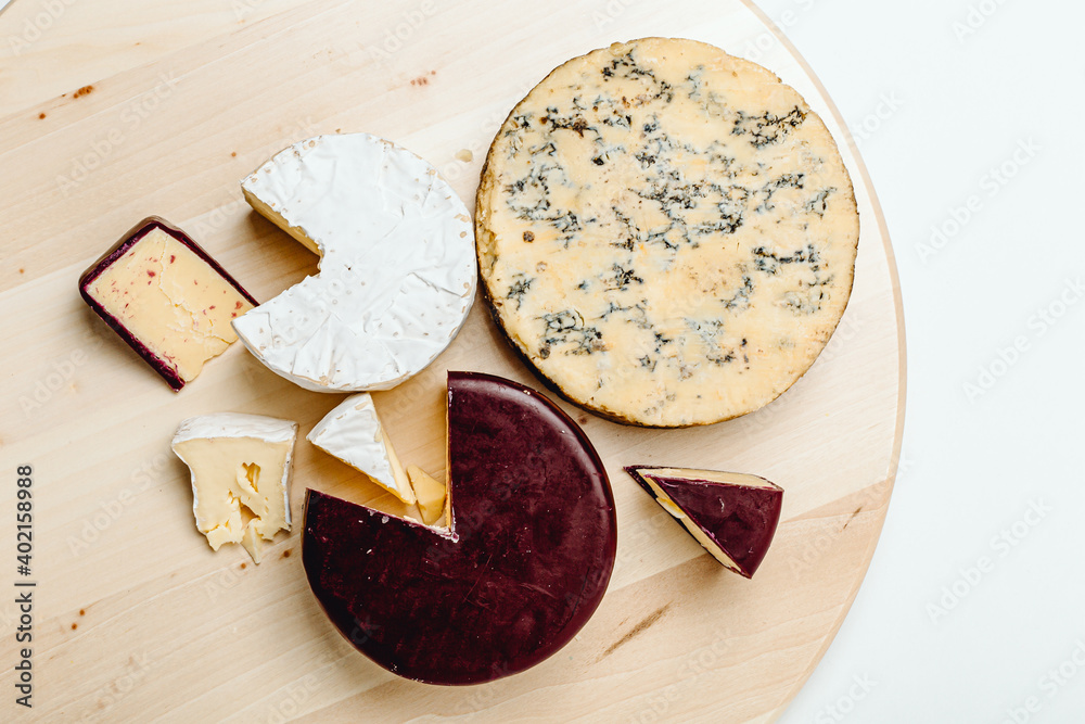 Assortment of different cheese types on dark and white background ...