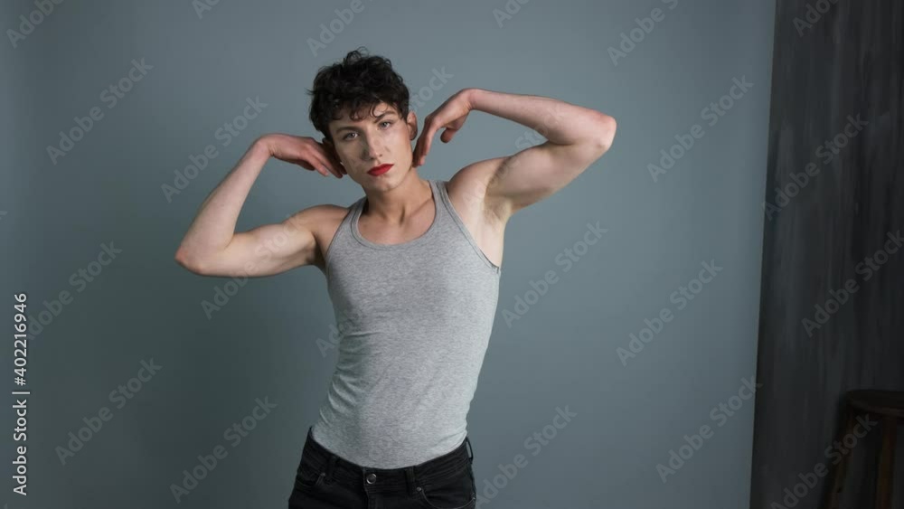 Portrait of a transgender with makeup posing on grey background. Medium ...