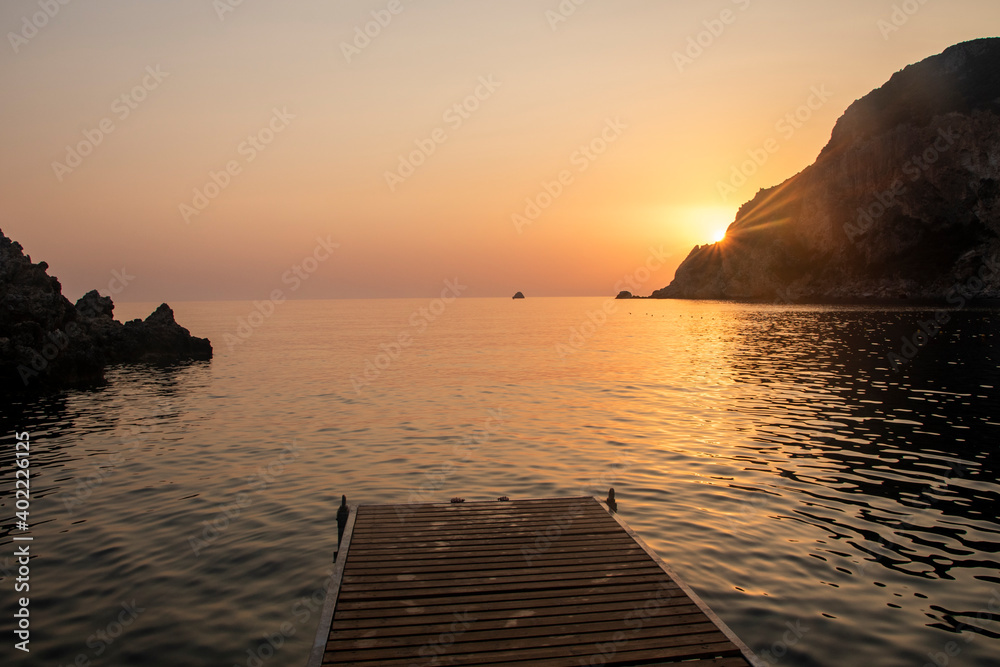 Silhouette of a man turned from behind while diving from a small marina ...