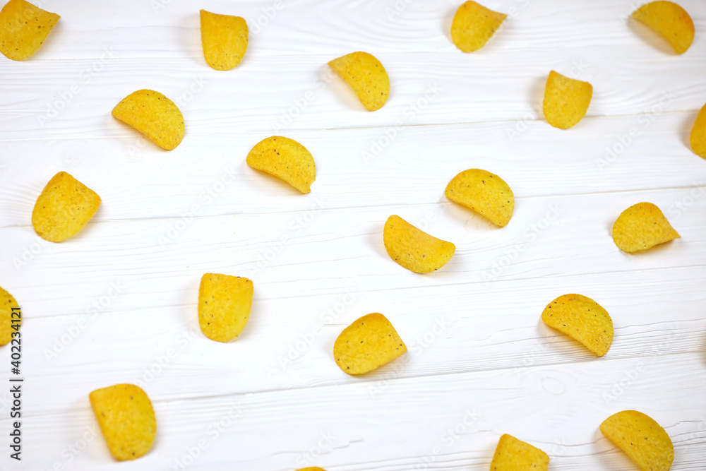 Many orange Pringles potato snack chips on white wooden table. Pringles ...