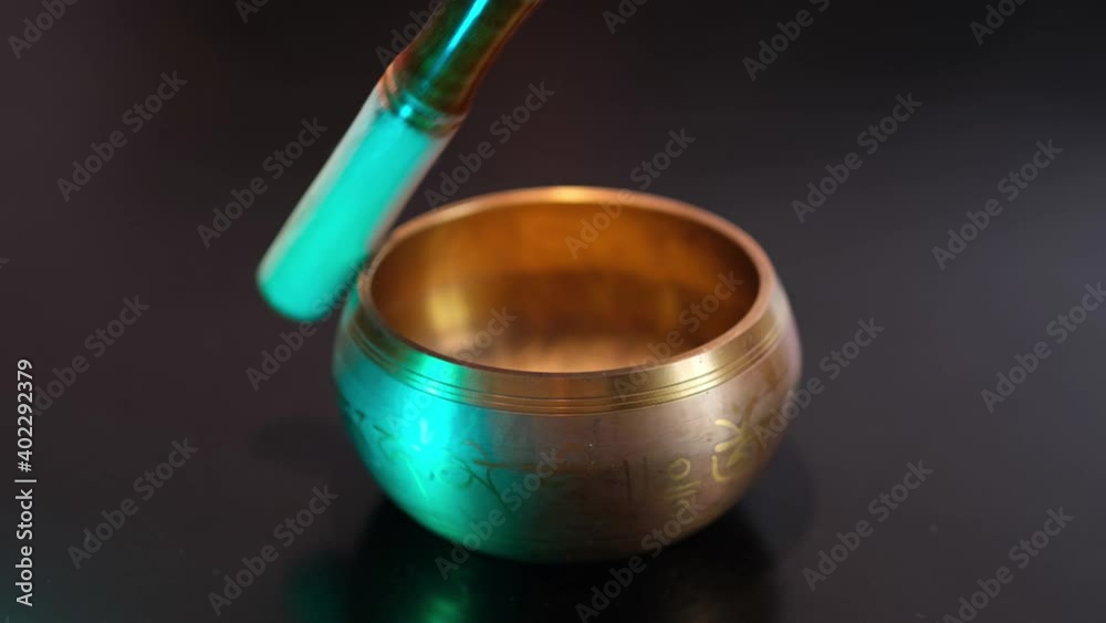 Singing Bowl from brass with wooden stick turning around the bowl ...