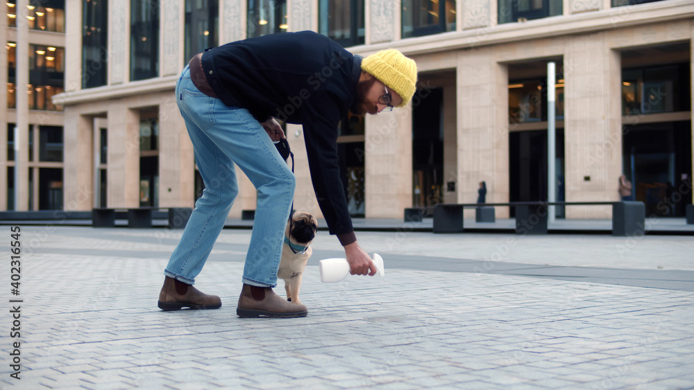 Man bending down and spraying with detergent pet pee on pavement ...