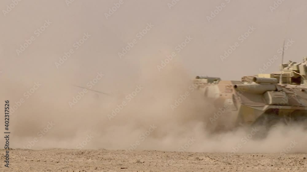 An armored personnel carrier drives through the sand in the desert ...