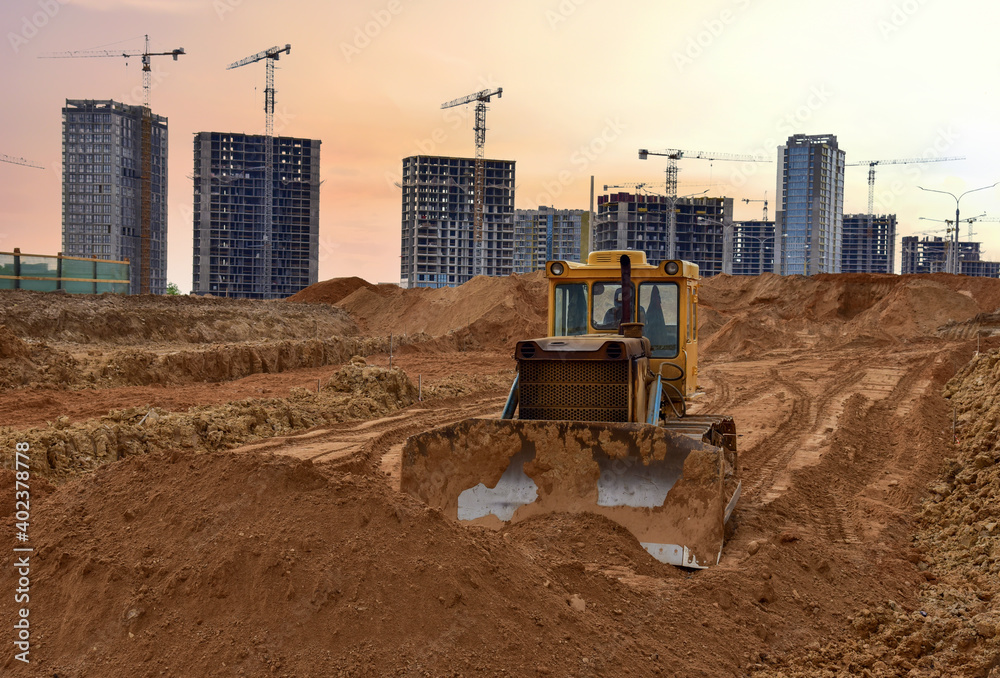 Dozer on earthmoving at construction site on sunset background ...