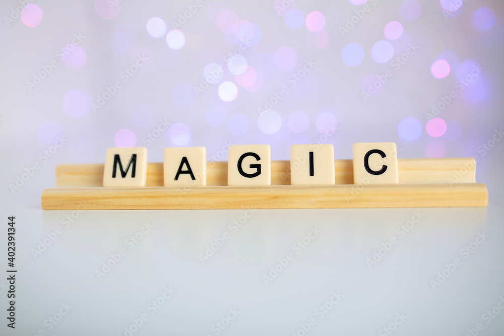 the word magic spelled out in scrabble tiles against a white background ...