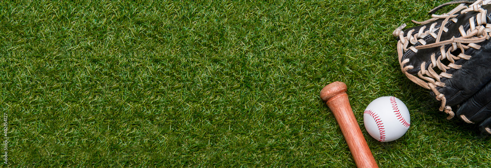 Baseball bat, glove and ball on green grass field. Sport theme ...