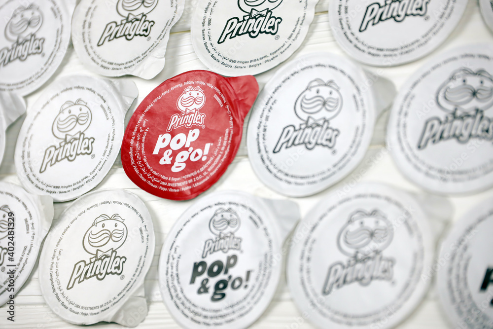 Pringles logo on paper membranes on white wooden table. Pringles is a ...
