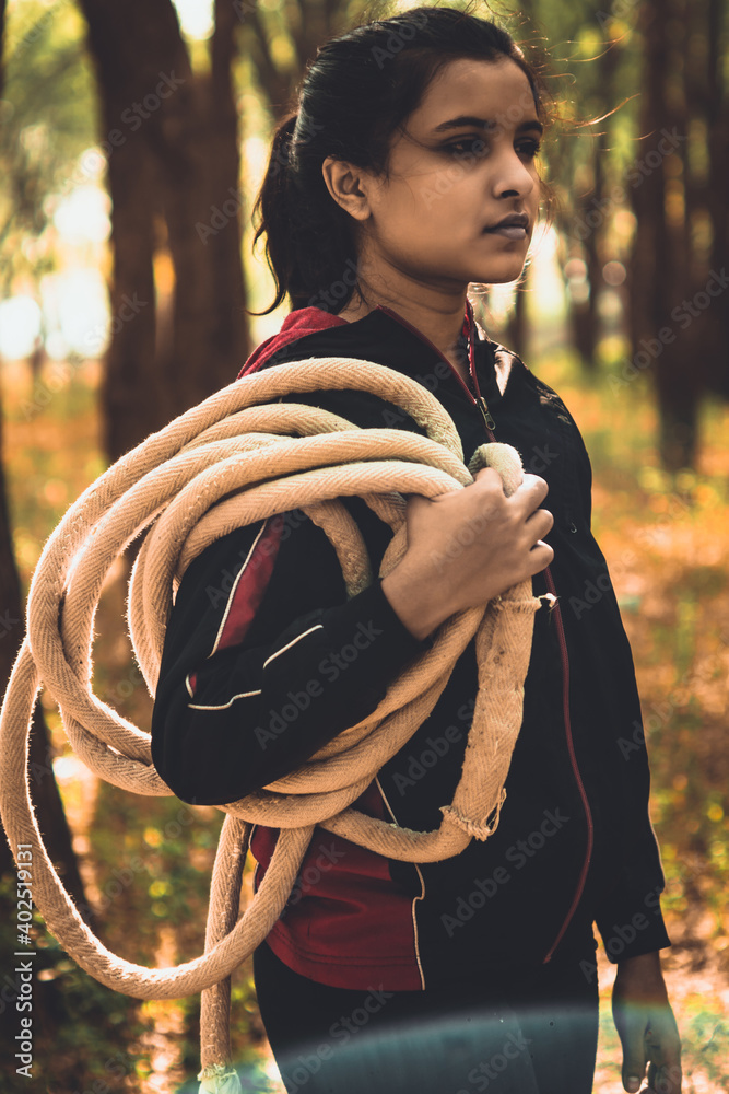 A sporty gymnast performs exercises with a rope in sportswear.Concept ...