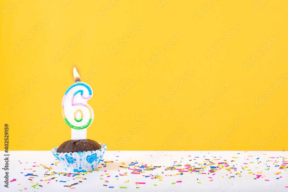 6 number candle on a cup cake with colorful sprinkles and yellow ...