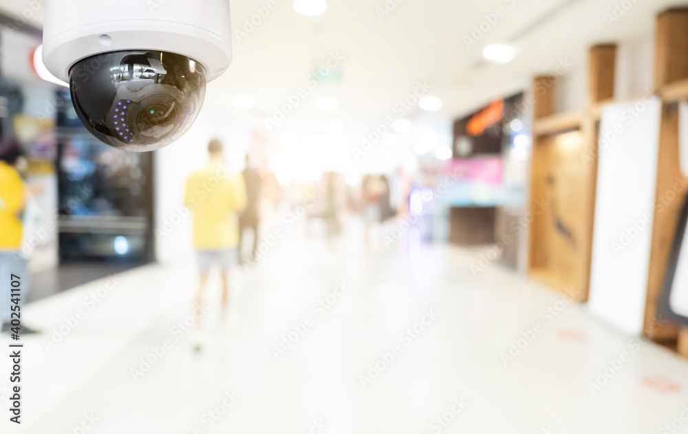 Modern public CCTV camera with blur interior shopping mall background ...