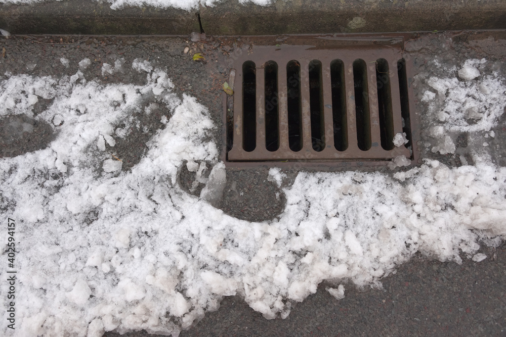Foto de 1 - Melting snow flows into an iron kerbside surface drain. do ...
