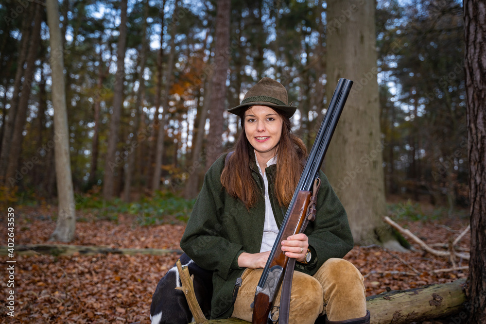 Jagd und Wildhege, junge Jägerin mit ihrem Jagdhund im Wald ...
