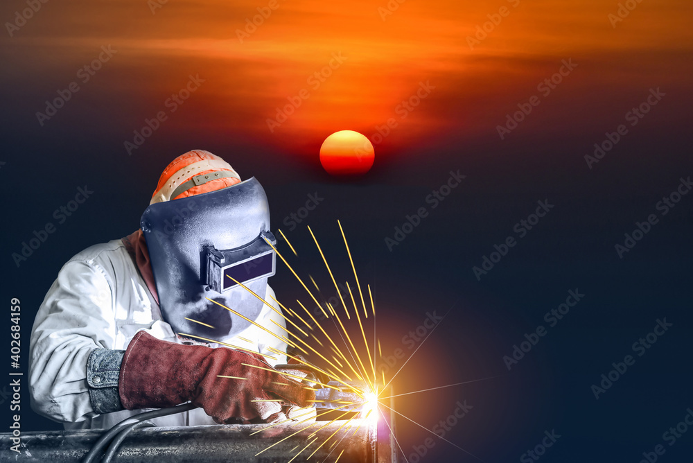 Welding worker on Metal steel pipe with spark light wear equipment ...