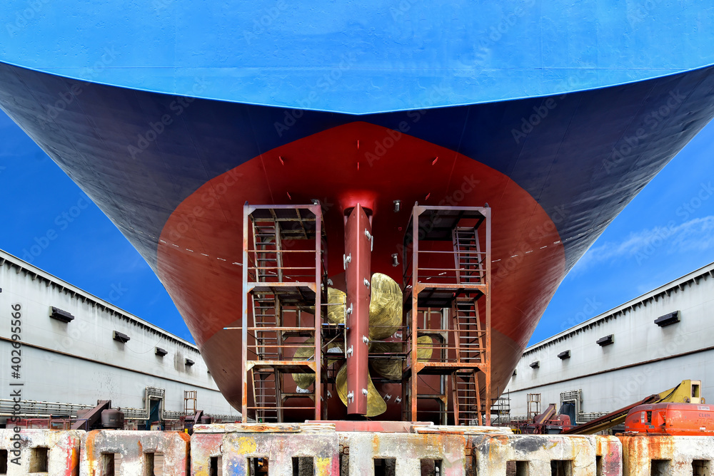 Detail of black stern big cargo ship and ship propeller, rudder red ...