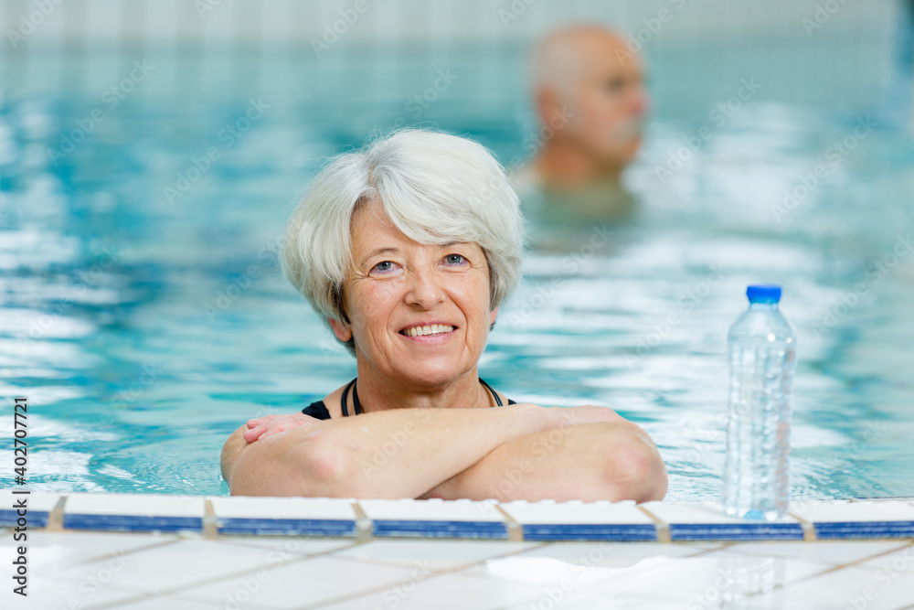 elderlyw woman in the swimming pool with bottled water beside Stock ...
