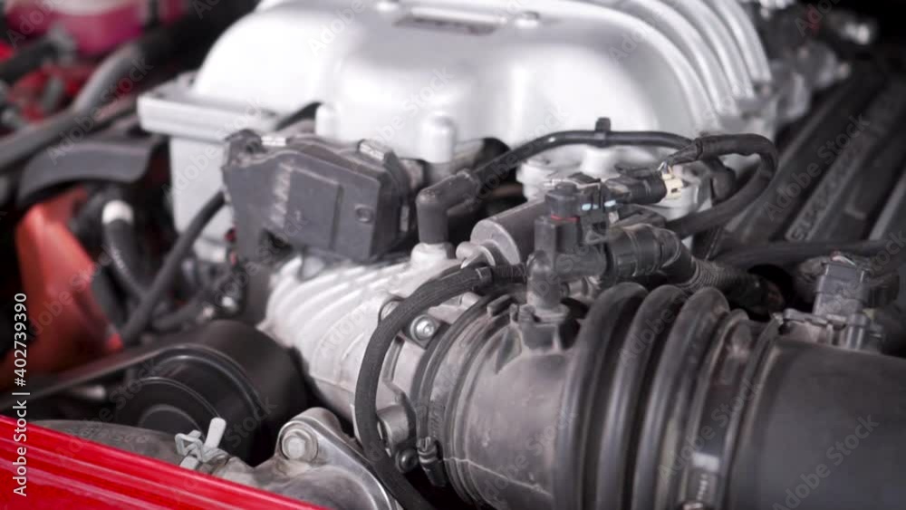 Starting the engine of a sports car. Footage. The drive belts of the ...