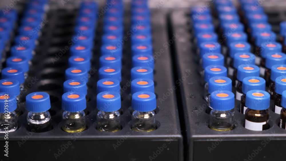 Automated conveyor line of auto sampler in HPLC system. Vials with blue ...