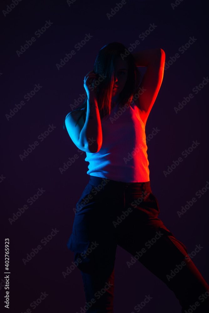 Blue and red light portrait of a female model on a black background ...