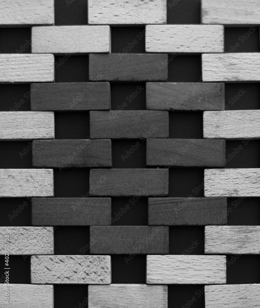 Wall made of small wooden bricks. Black and white wooden blocks ...