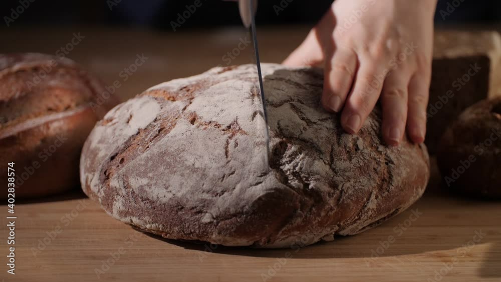 Cutting of a fresh, homemade and organic bread loaf with flour on ...