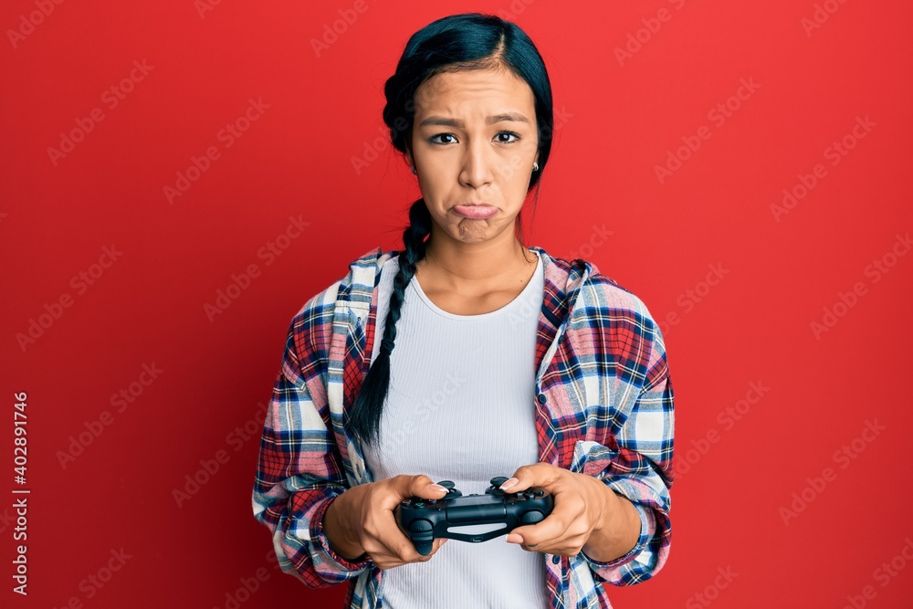 Beautiful hispanic woman playing video game holding controller ...