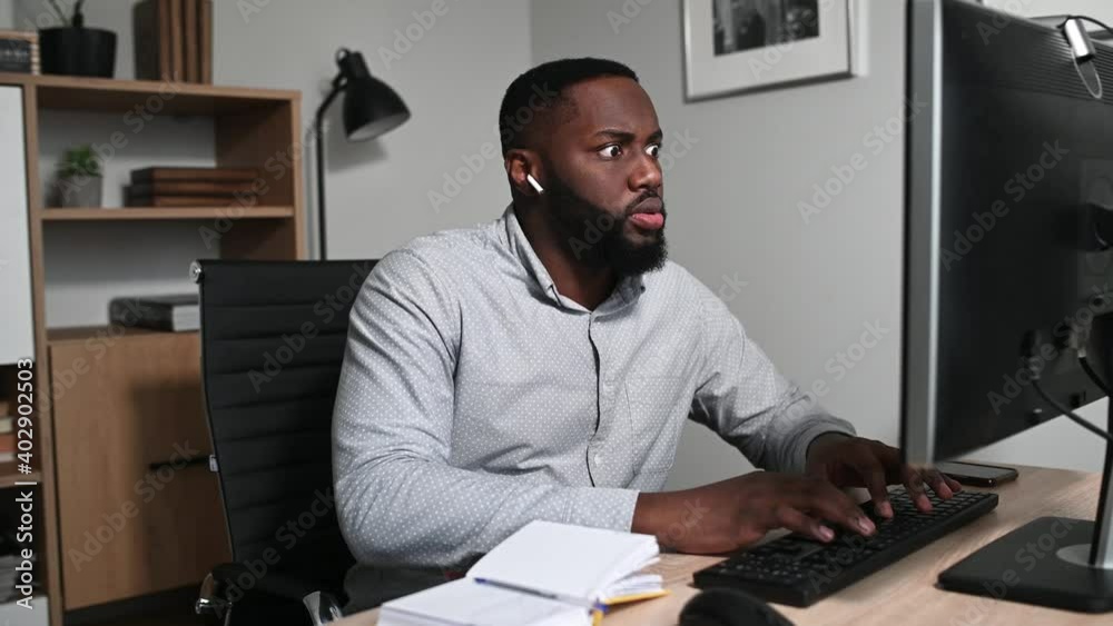 Shocked African-American guy staring on computer screen. A frustrated ...