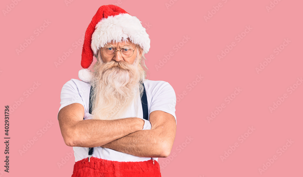 Old senior man with grey hair and long beard wearing santa claus ...