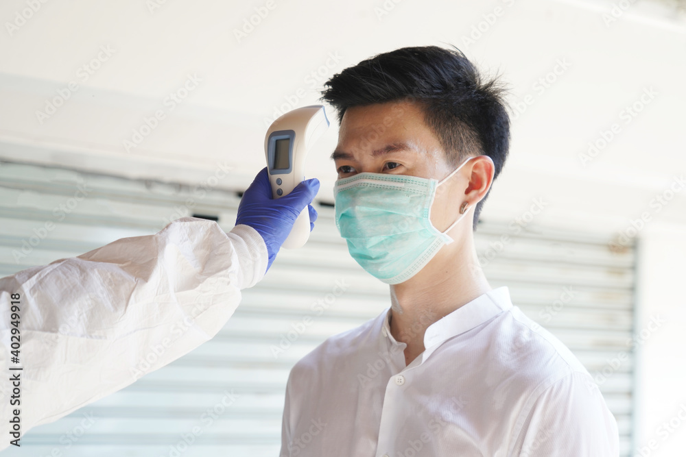 Disease control experts use an Infrared thermometer equipment to check ...