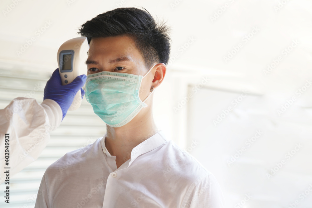 Disease control experts use an Infrared thermometer equipment to check ...