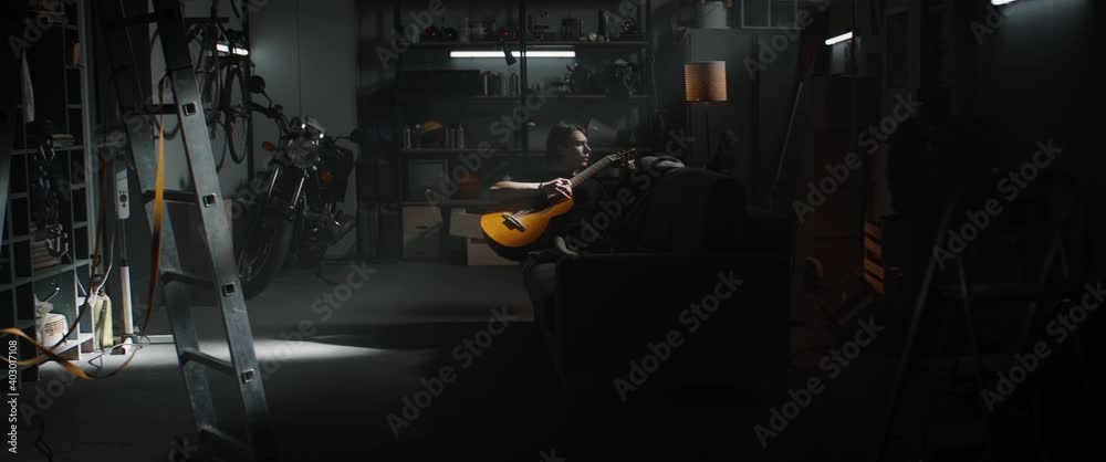 WIDE Caucasian teenager boy lying on a sofa in his home garage hideout ...