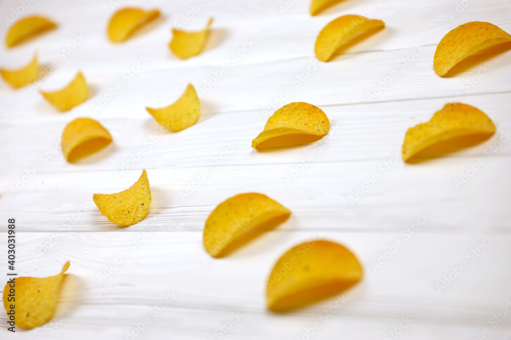 Many orange Pringles potato snack chips on white wooden table. Pringles ...